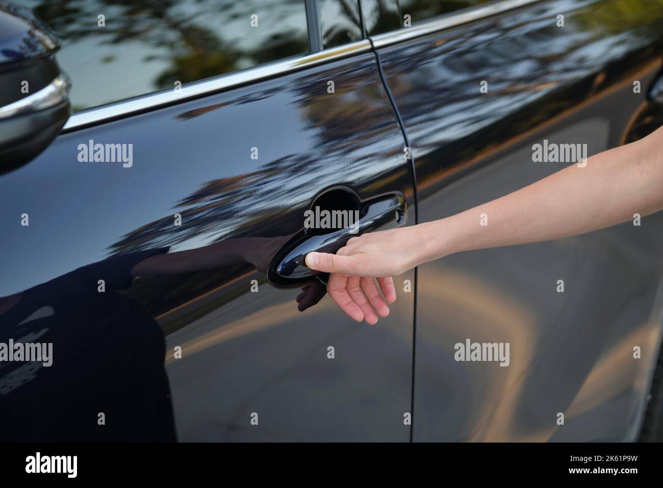Closeup of driver hand opening car front door with touch ID finger ...