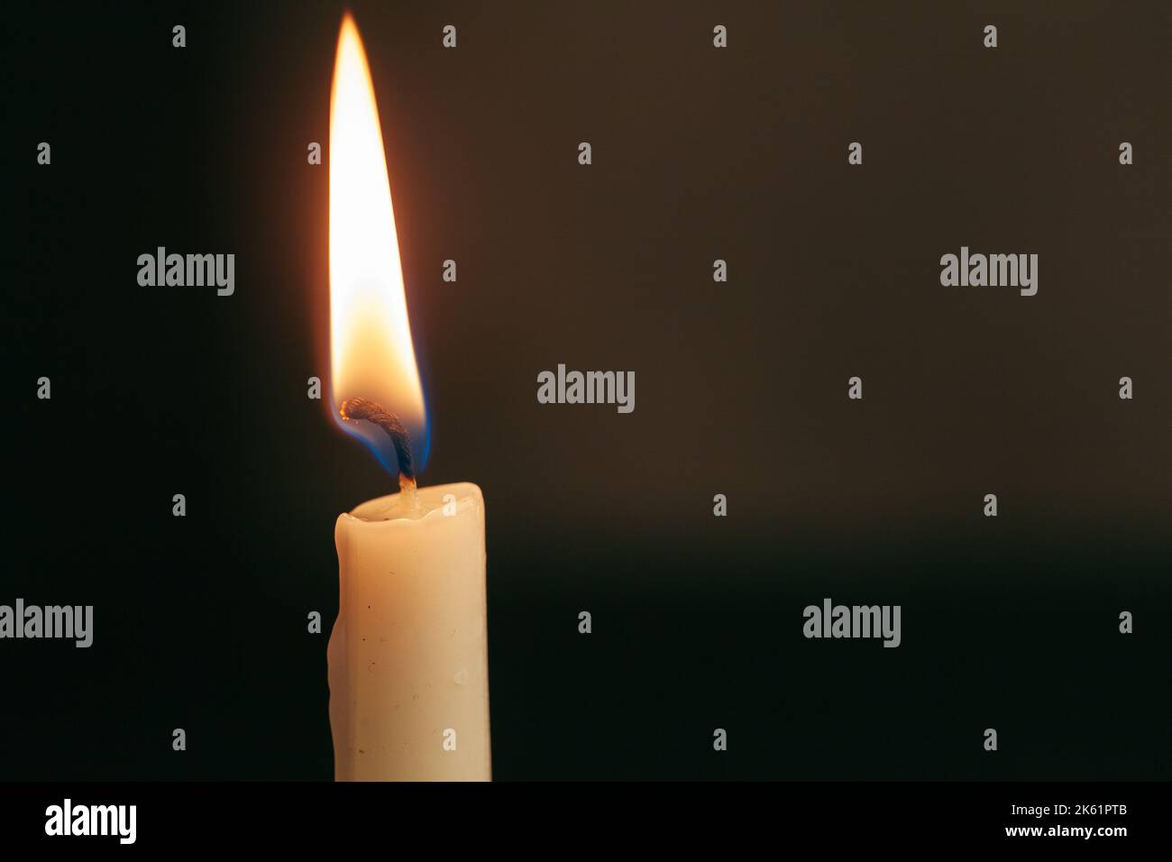 A single burning candle isolated with black background Stock Photo - Alamy