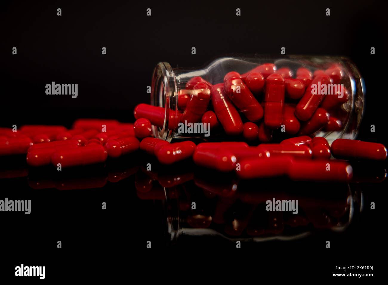 A bunch of red pillars spilled from a small glass jar isolated on an ...