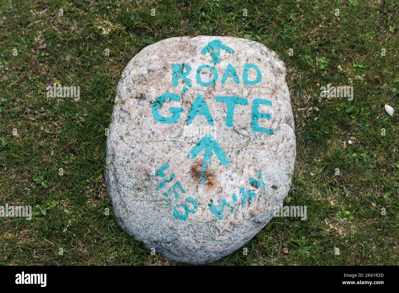 A sign showing the way to Road Gate Hebridean Way written on a rock ...