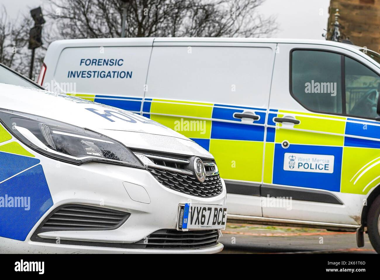 Side low view of police vehicles parked with no officers inside. A ...