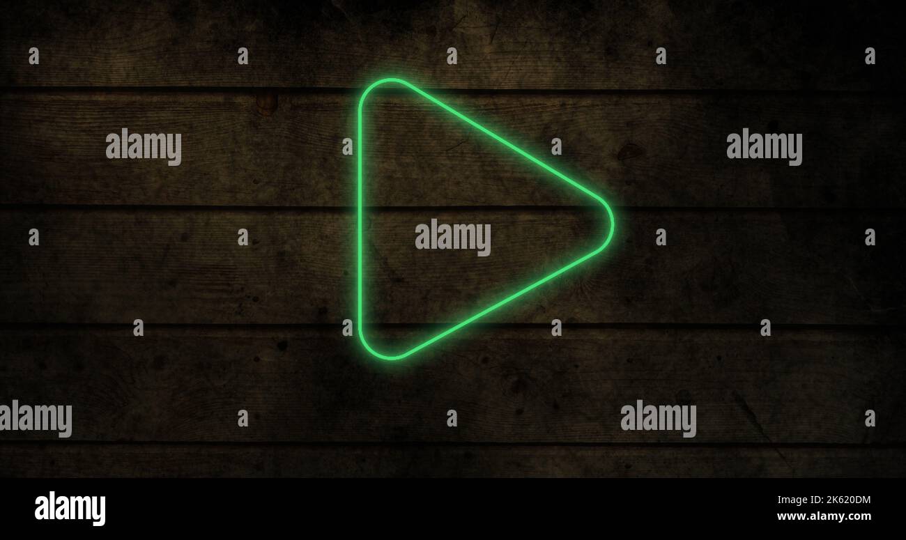 Composite of illuminated play button icon over wooden wall, copy space ...