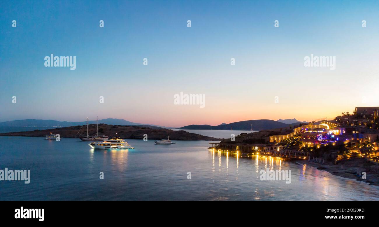 Night view to large illuminated boat near luxury resort, colorful ...