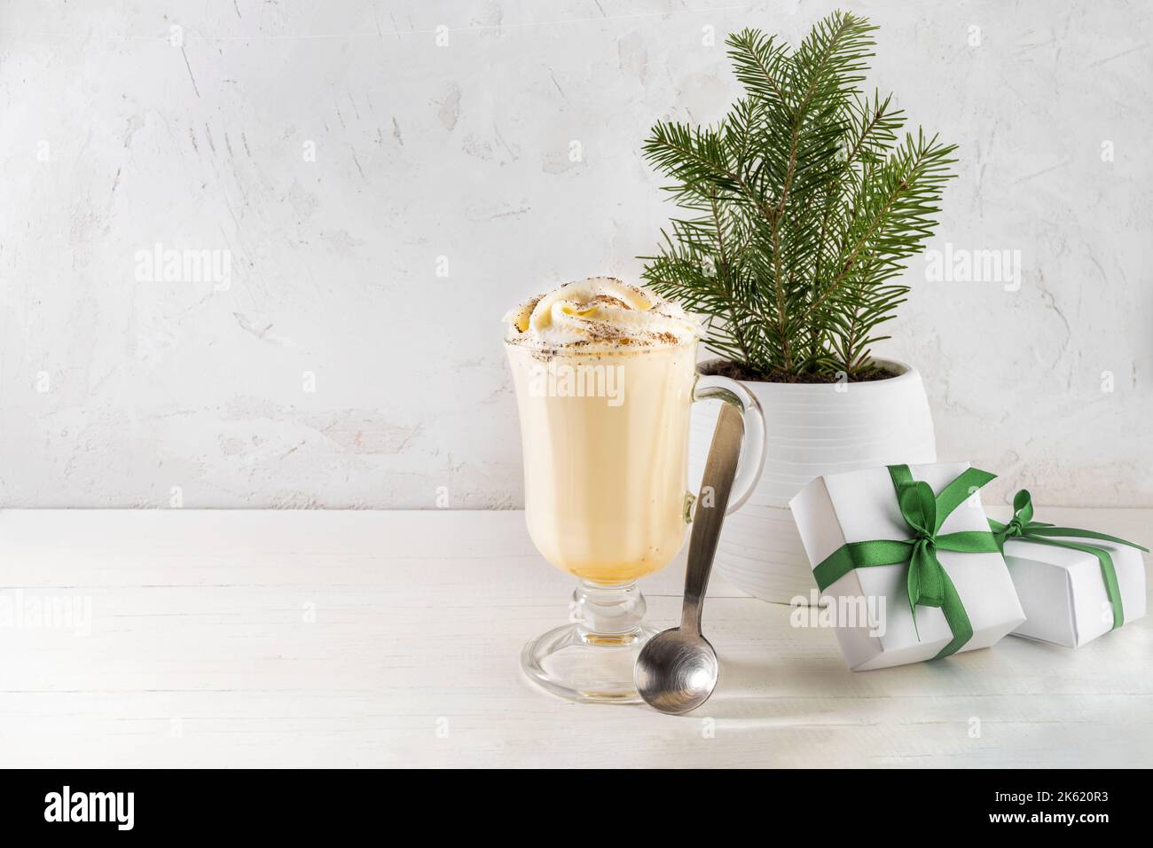 Christmas composition on white. Glass of traditional drink eggnog with ...