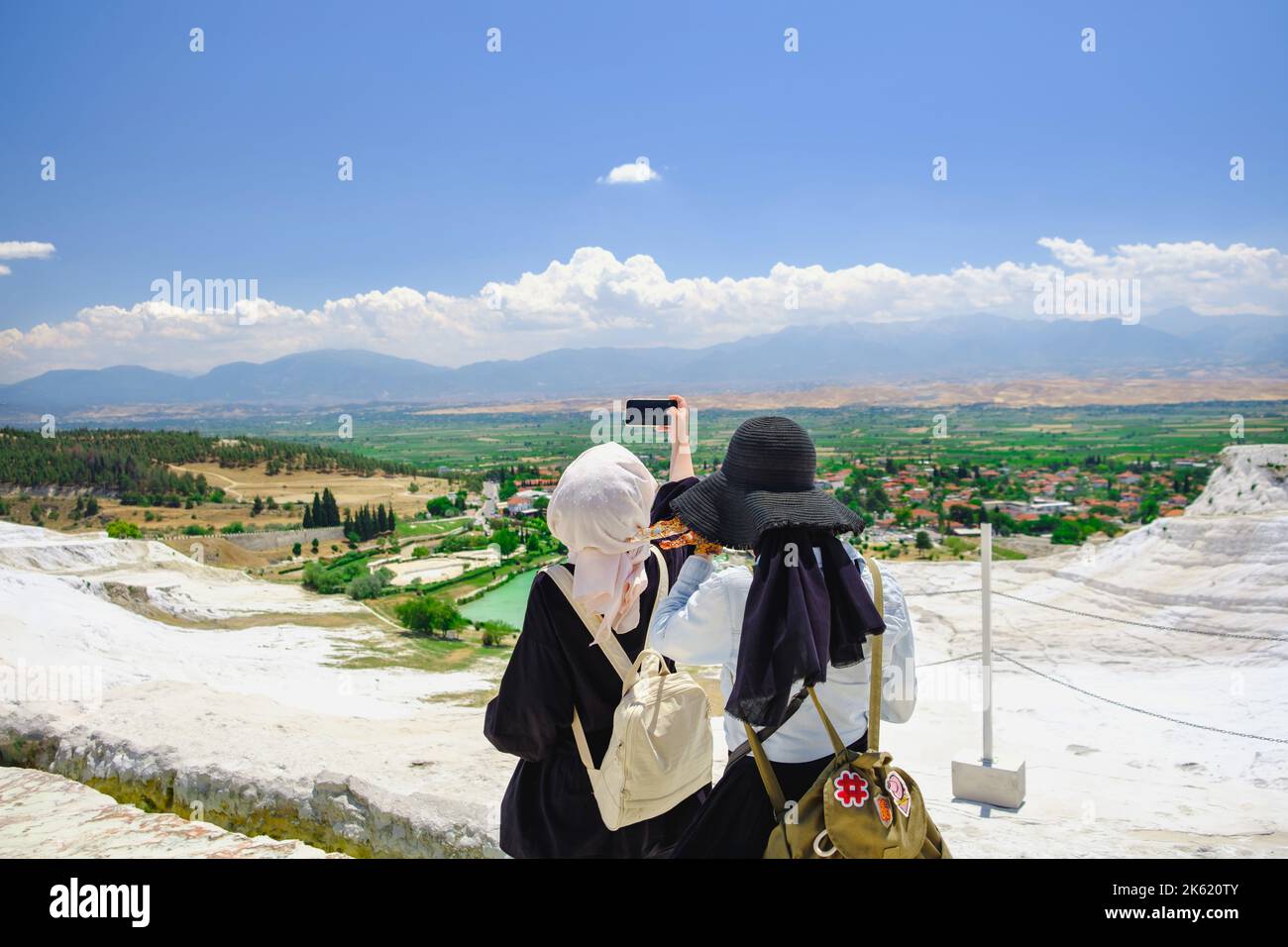 Woman with her friend taking a photo of the beautiful landscape ...