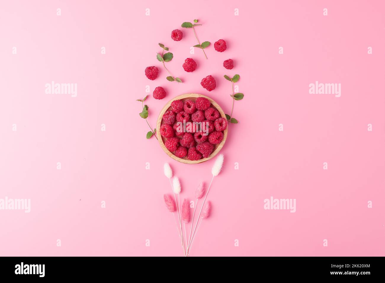 Creative summer background made from fresh berries and flowers on pink ...