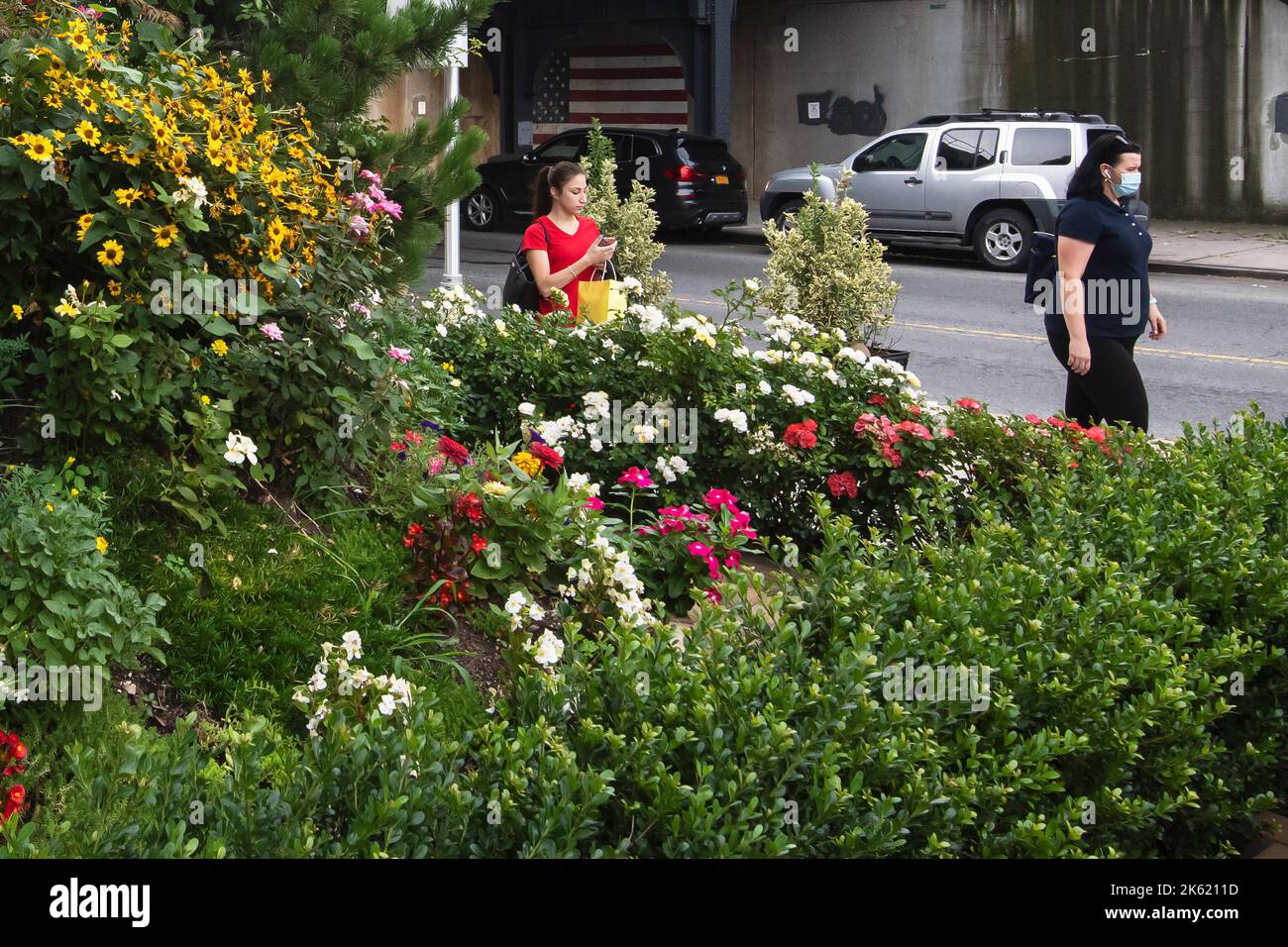 Green-space garden and passers by in Ridgewood New York Stock Photo - Alamy