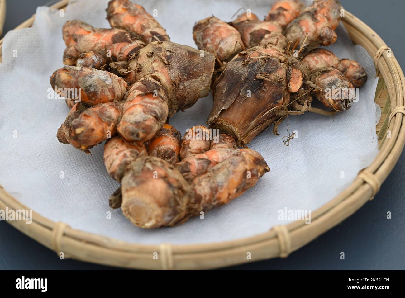Fresh orange turmeric on a bamboo plate Stock Photo - Alamy