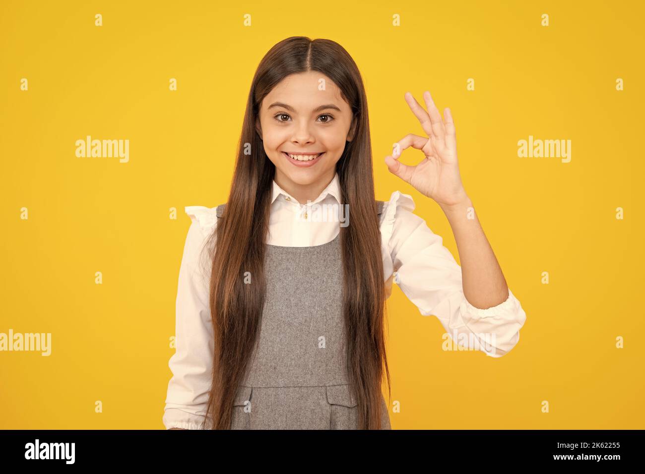 Beautiful child girl making ok sign on yellow background. Portrait of ...