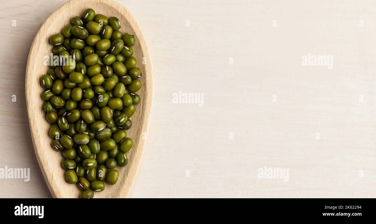 Directly above close-up shot of green mung beans in wooden plate over ...