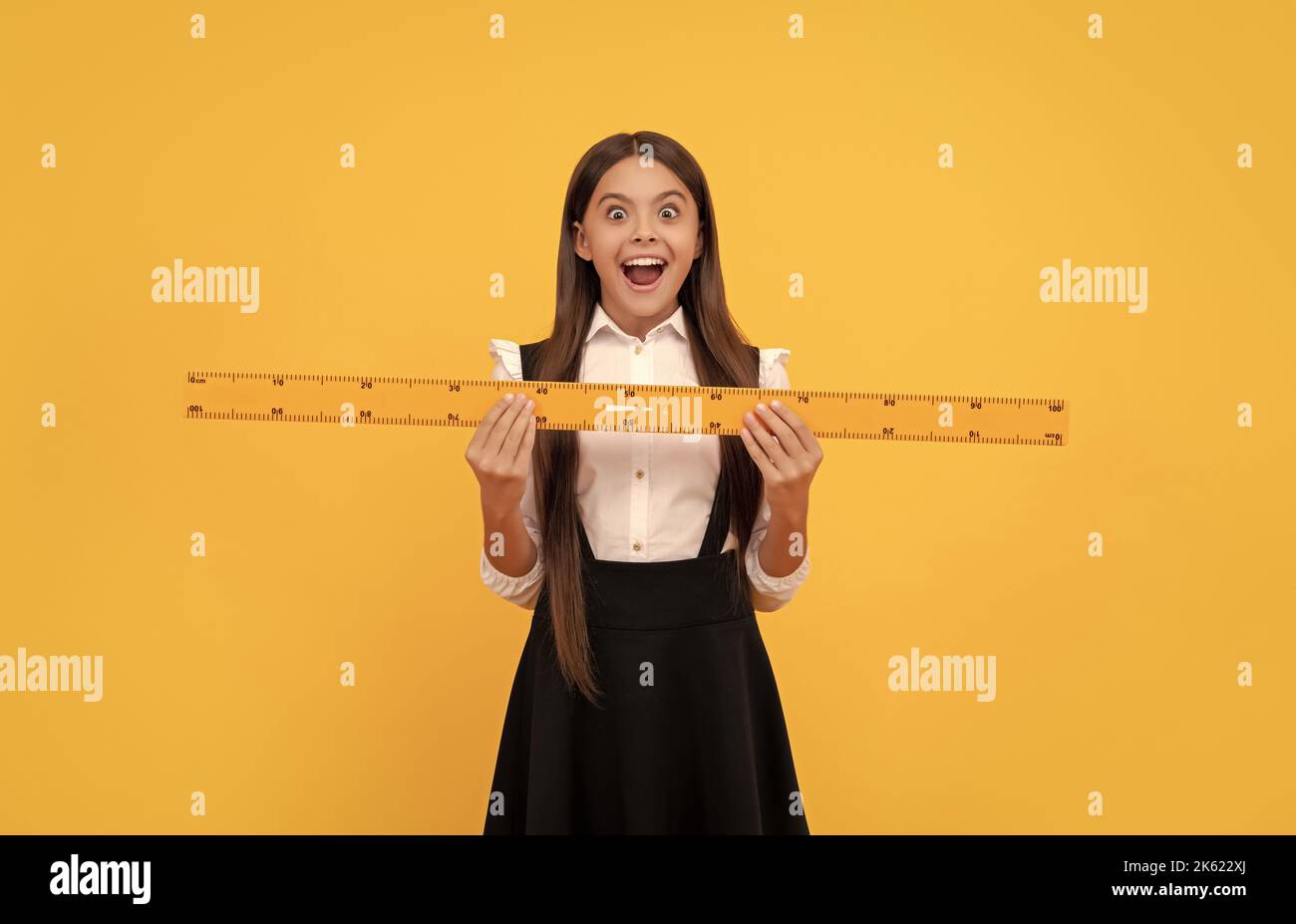 amazed teen girl in school uniform hold mathematics ruler for measuring ...