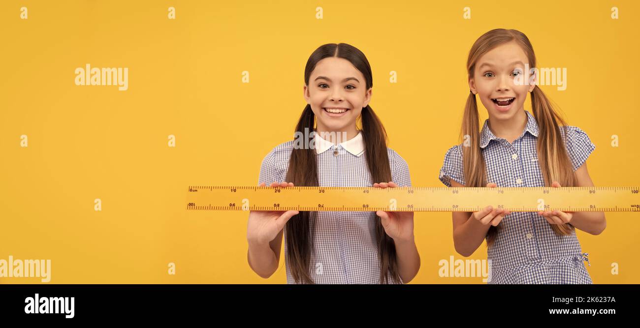 School girls friends. Happy schoolchildren hold wooden ruler. Geometry ...