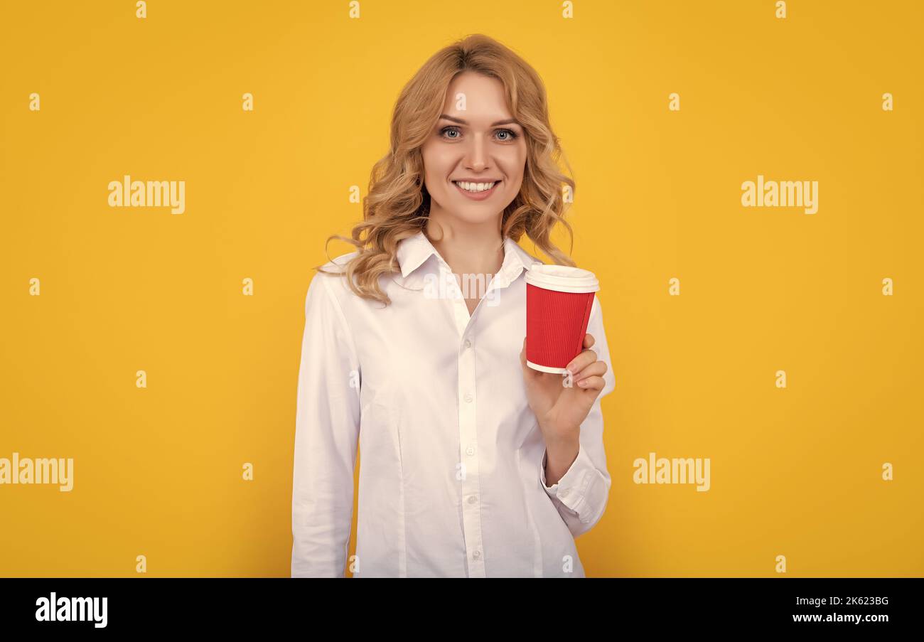 cheerful blonde woman with coffee cup on yellow background Stock Photo ...