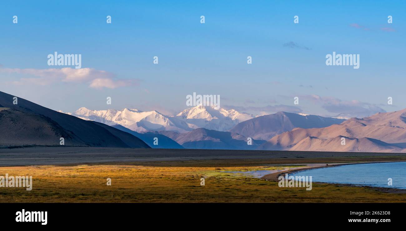 Landscape view of shore of Karakul lake at sunrise, with Muskol snow ...