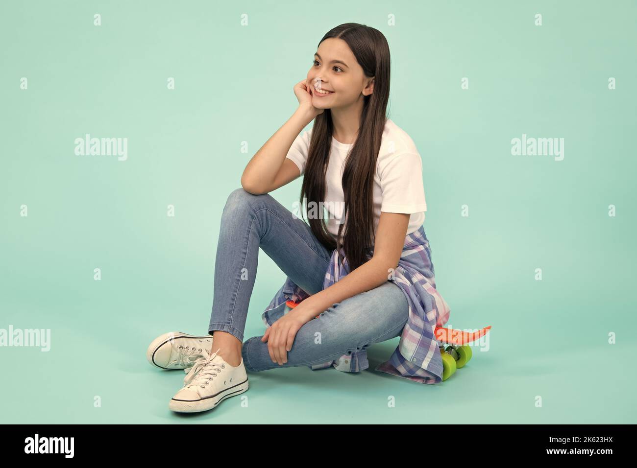 Fashionable confident teenage girl wearing trendy t-shirt and jeans sit ...