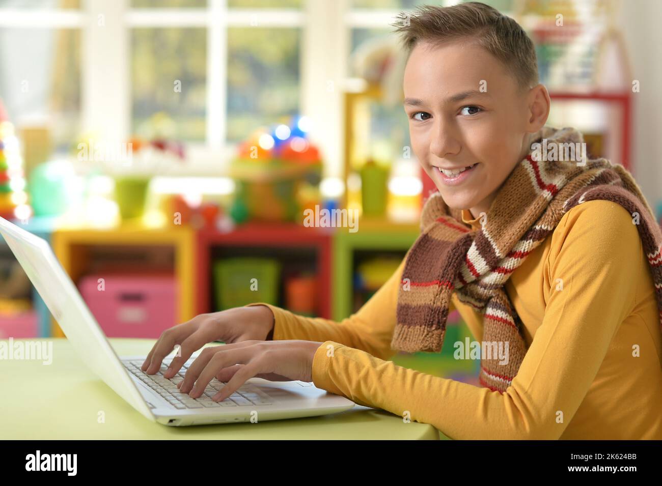 Cute boy with laptop at the table Stock Photo - Alamy