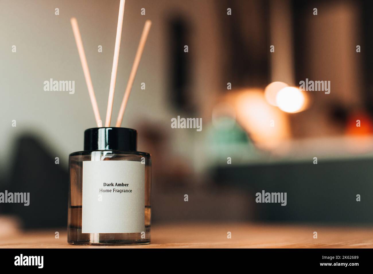 Stylish glass bottle with wood stick aroma diffusers on wooden table ...