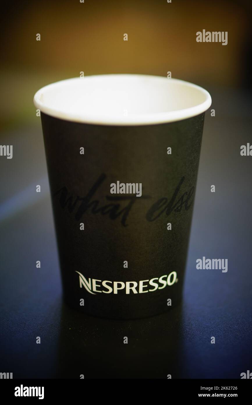 A vertical shot of a Nespresso coffee paper cup on the table Stock ...