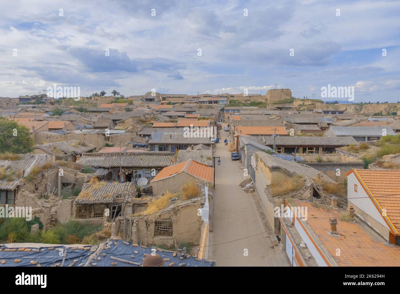 A view of a Yuzhou city neighbourhood in China, with a dirt road and a ...