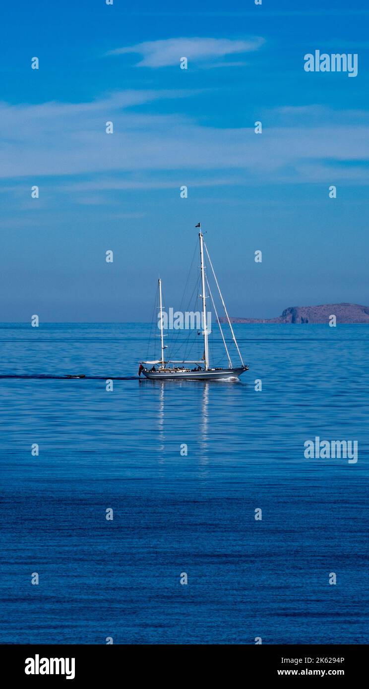 A vertical shot of a sailboat floating in the middle of a sea Stock ...