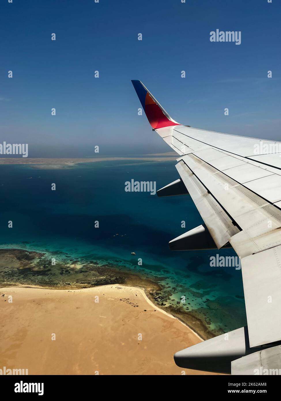 An airplane wing over a beautiful beach Stock Photo - Alamy