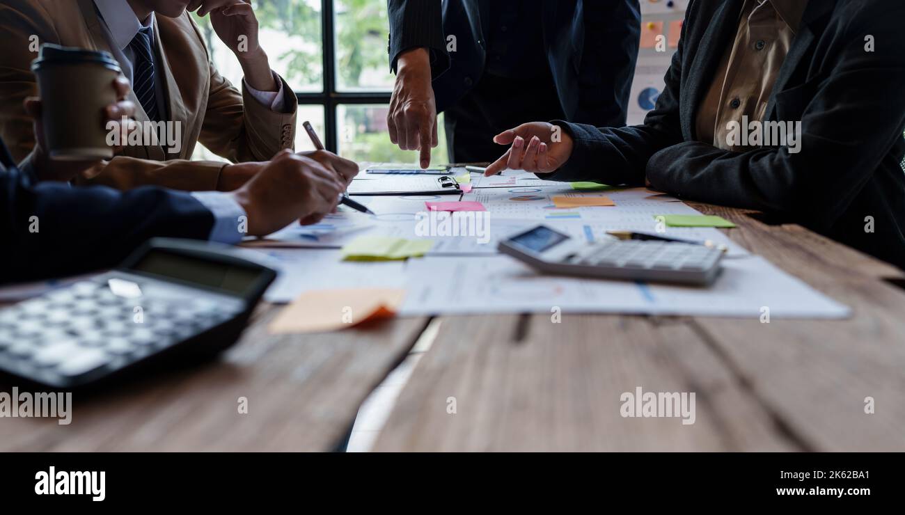 Asian Business people or Accountant do math and analyze with calculator ...