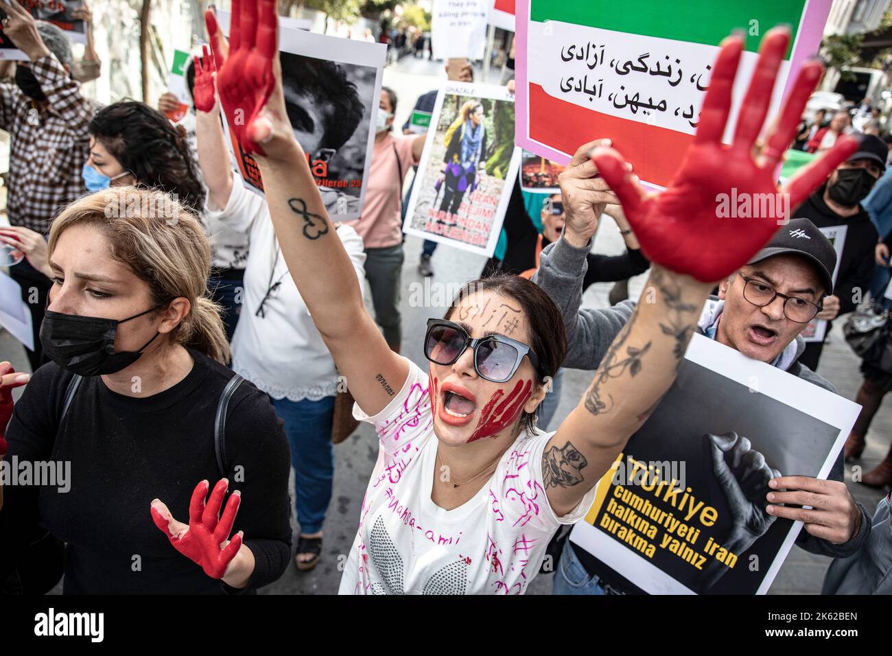 Protesters chant slogans with red painted hands and faces during the ...