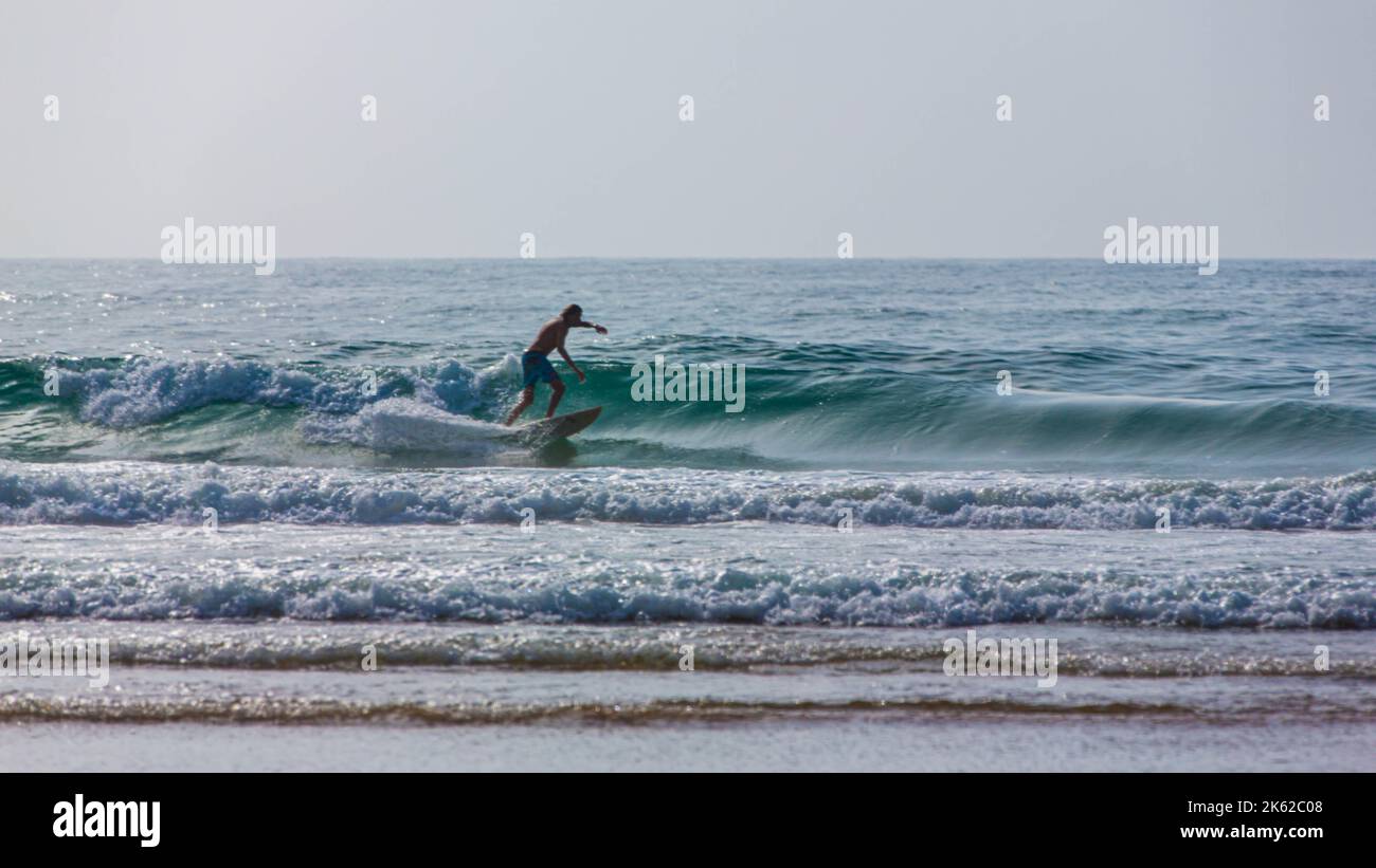 A man is surfing on a surfboard in Agadir beach Stock Photo - Alamy
