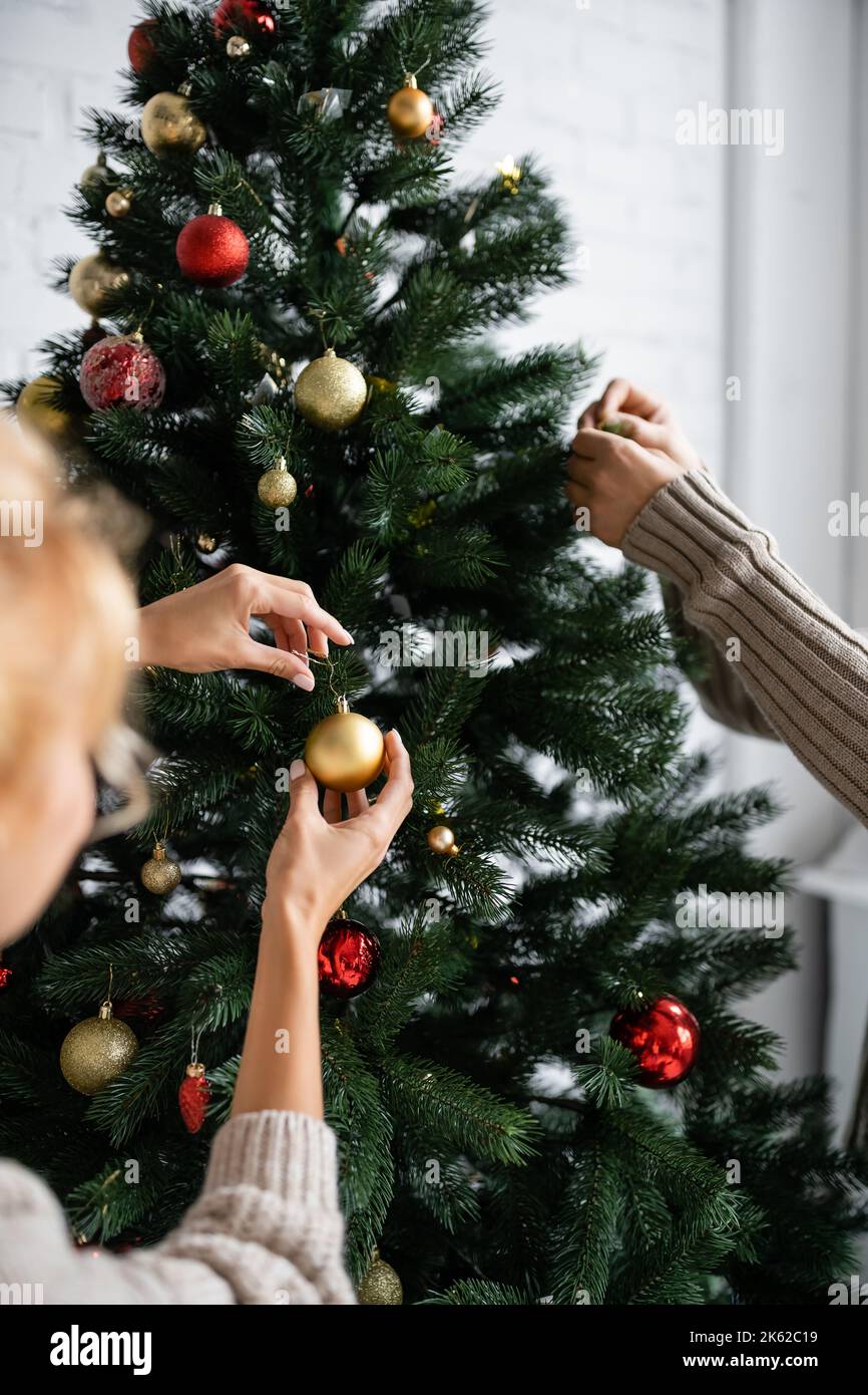 Blurred woman decorating christmas tree with husband at home,stock ...