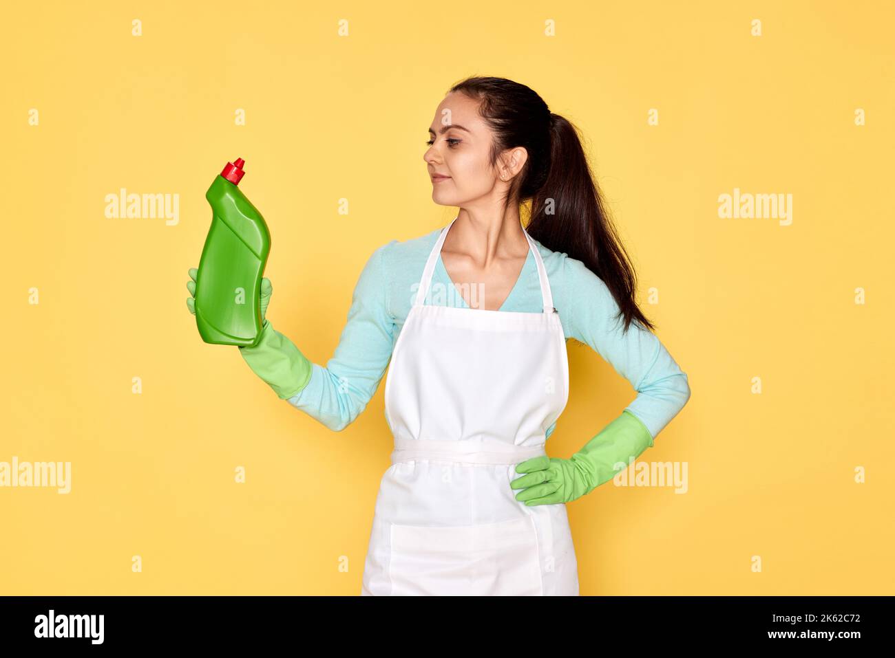 woman in gloves and cleaner apron holding bottle of detergent Stock ...