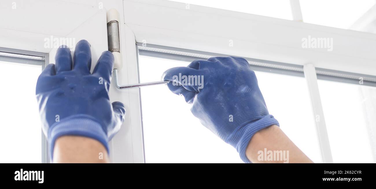 installation of plastic in a frame house, the builder screws the window ...
