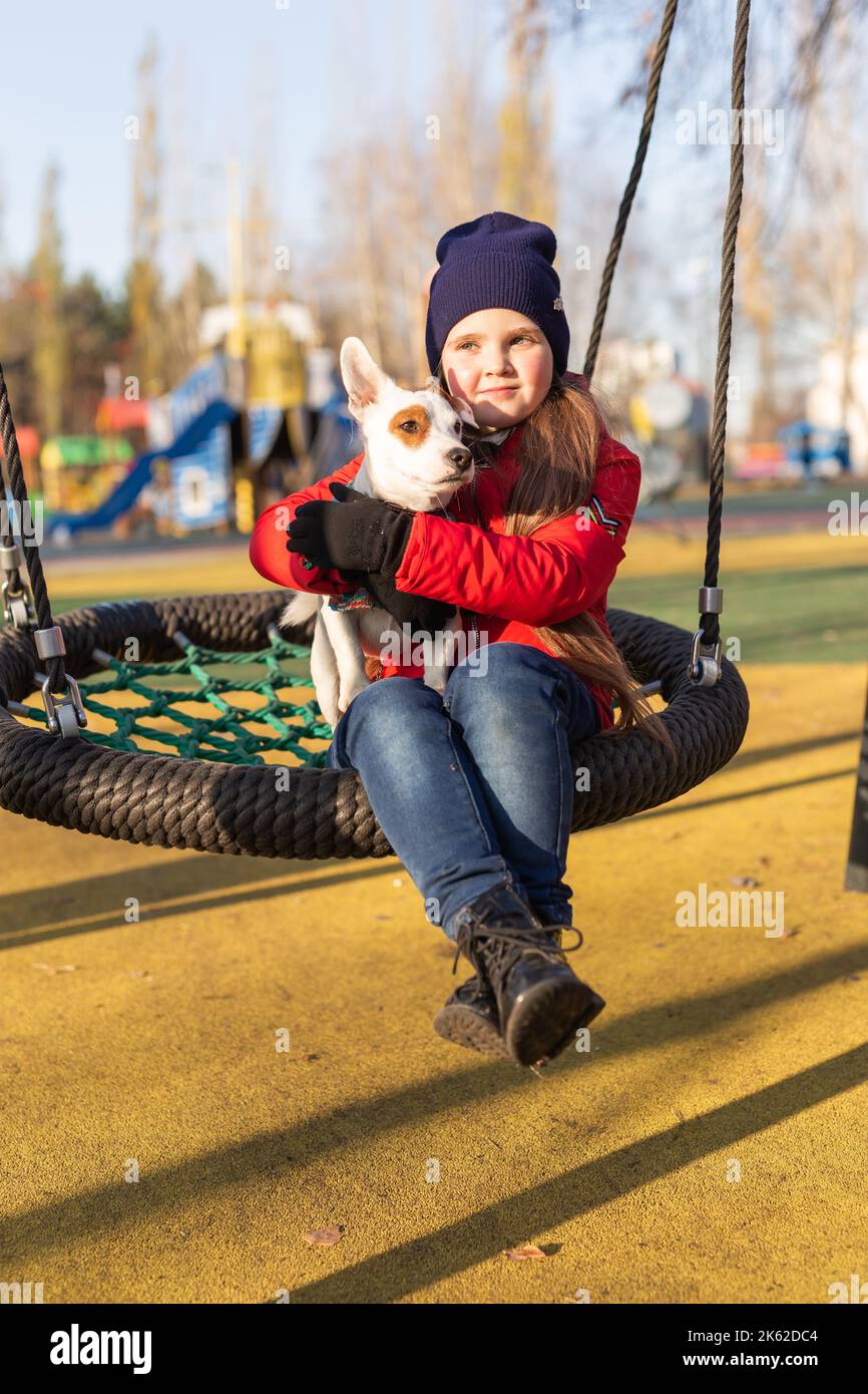 Happy child girl with dog. Portrait kid with pet Jack Russell Terrier ...