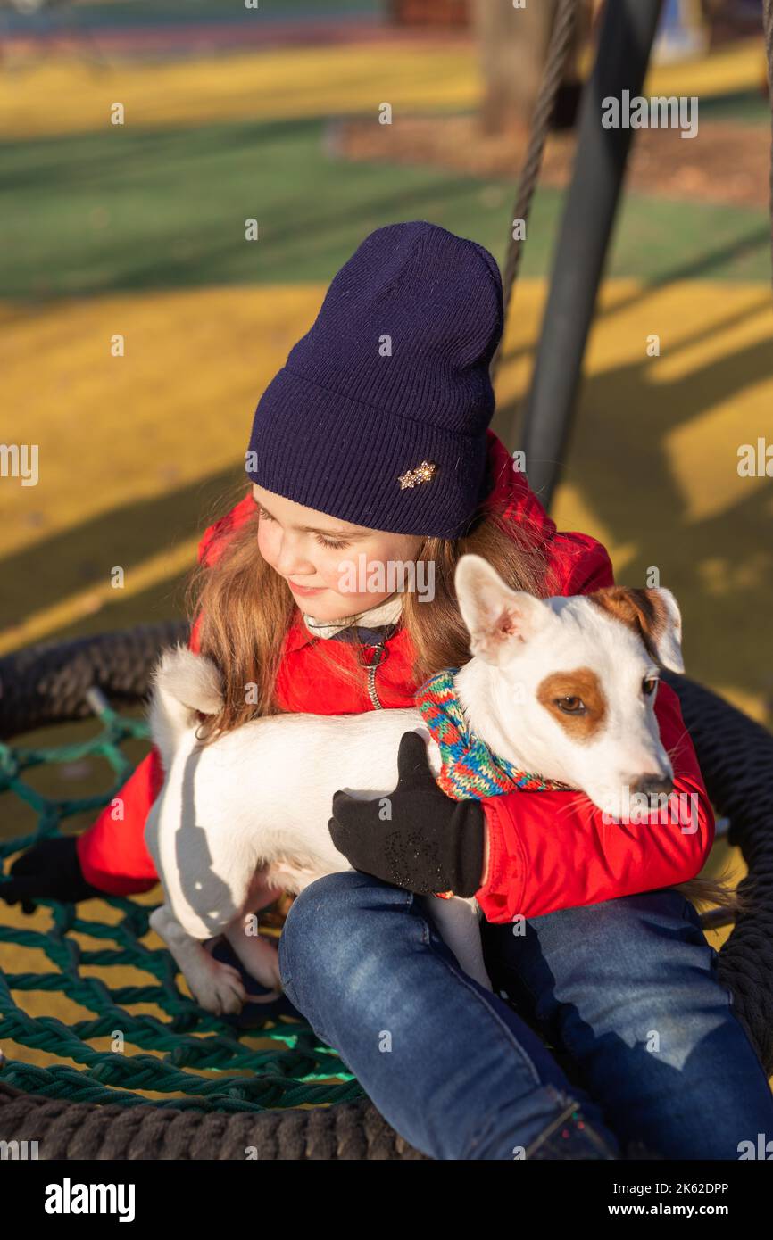Happy child girl with dog. Portrait kid with pet Jack Russell Terrier ...