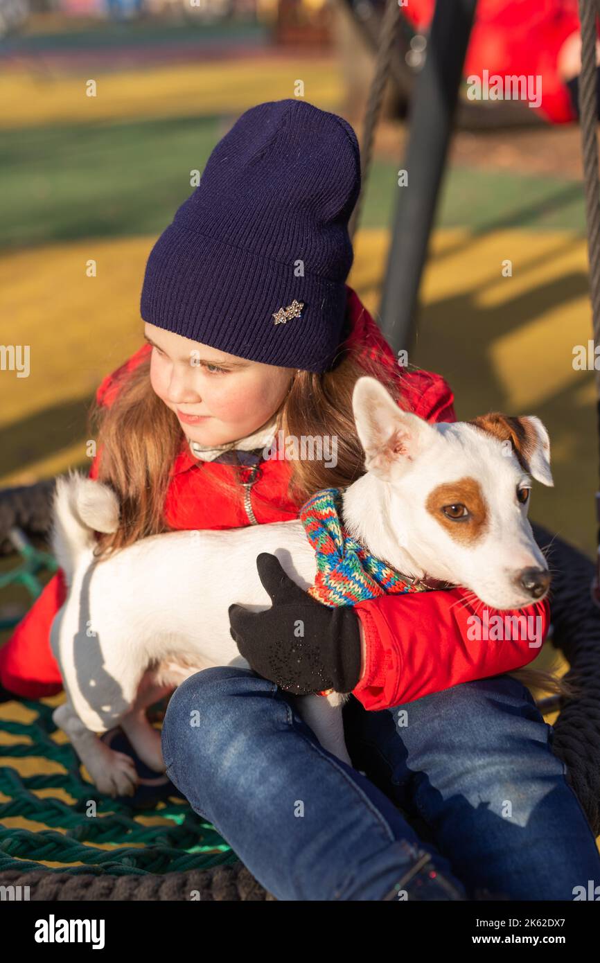 Happy child girl with dog. Portrait kid with pet Jack Russell Terrier ...