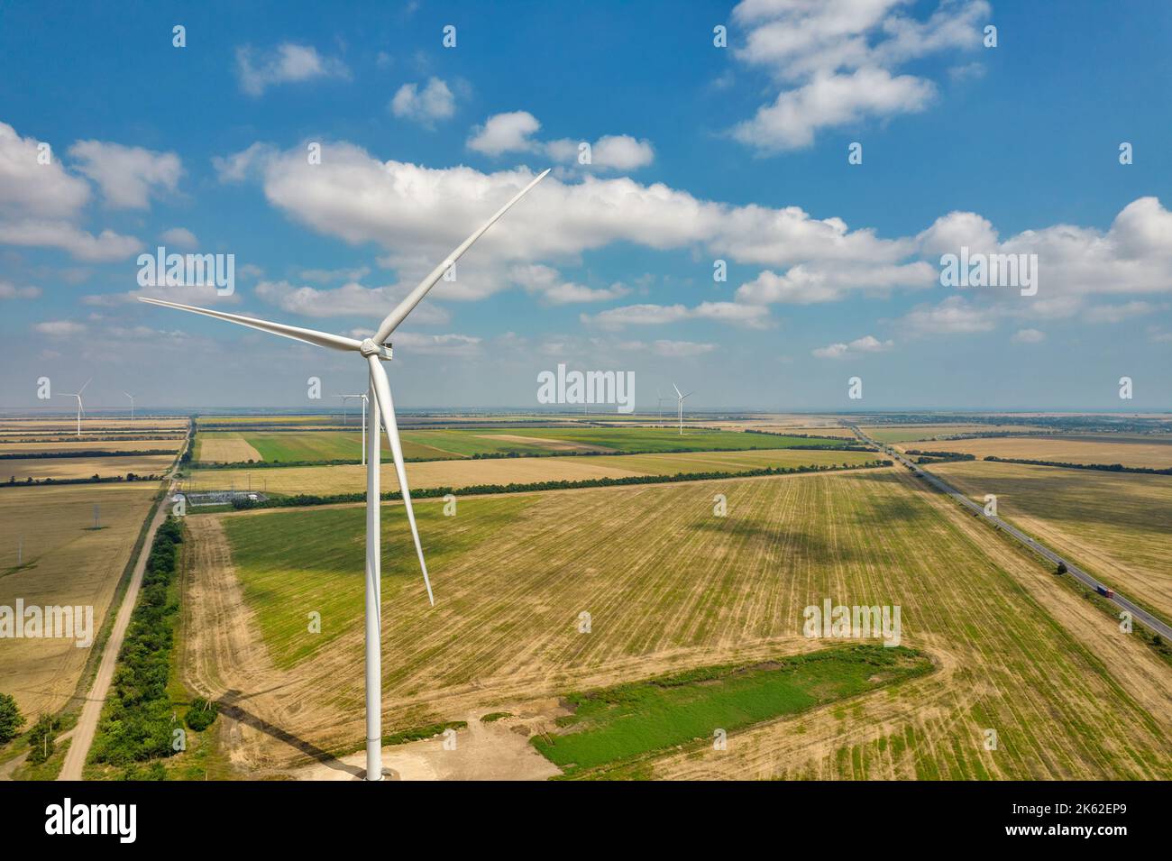 Drone view over wind farm turbine closeup against blue sky with clouds ...