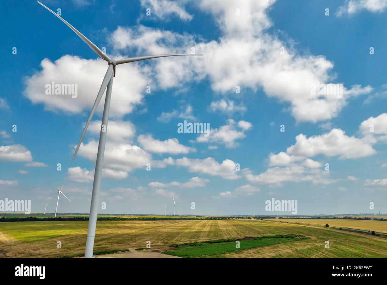 Drone view over wind farm turbine closeup against blue sky with clouds ...