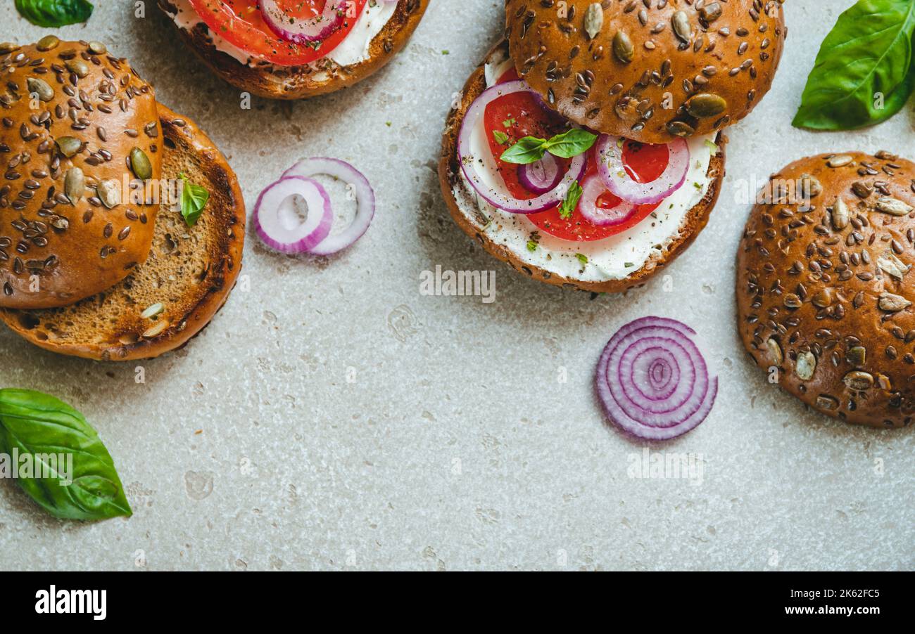 Top view of rye bread rusted buns with cream cheese, fresh tomato ...