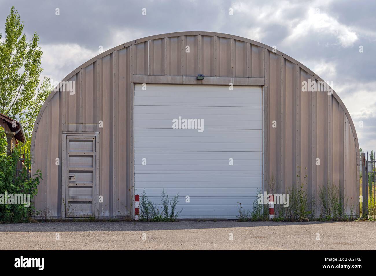 Big Arch Metal Storage Building With Garage Door Stock Photo - Alamy