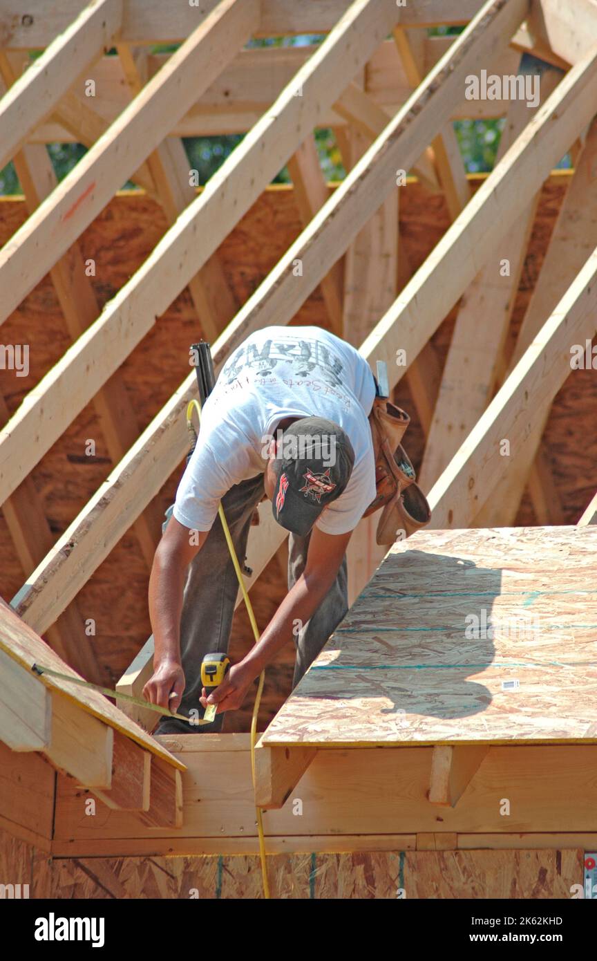 Roofers putting on sub roof of particle board on new home construction ...