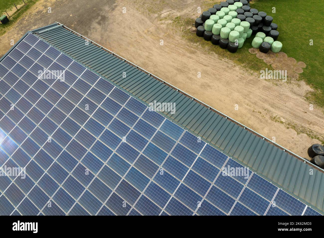Aerial view of blue photovoltaic solar panels mounted on farm building ...