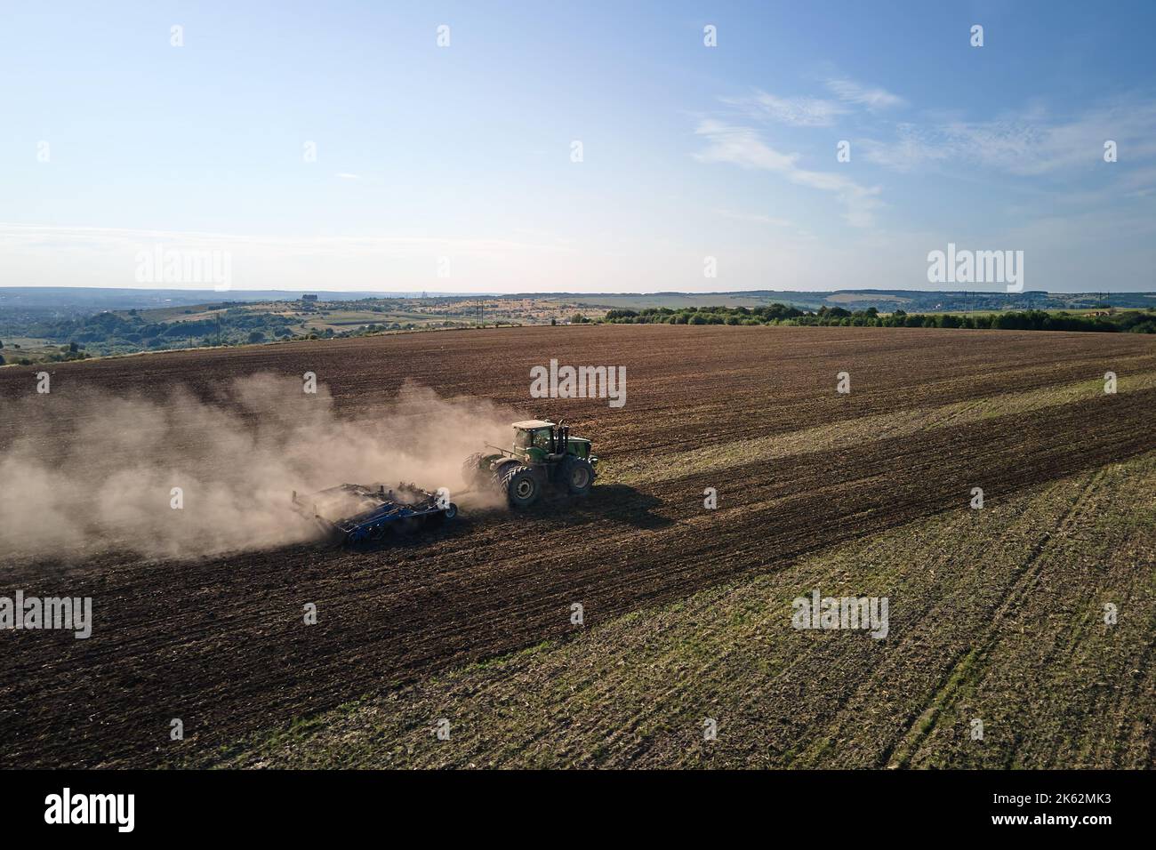 Aerial view of tractor plowing agriculural farm field preparing soil ...