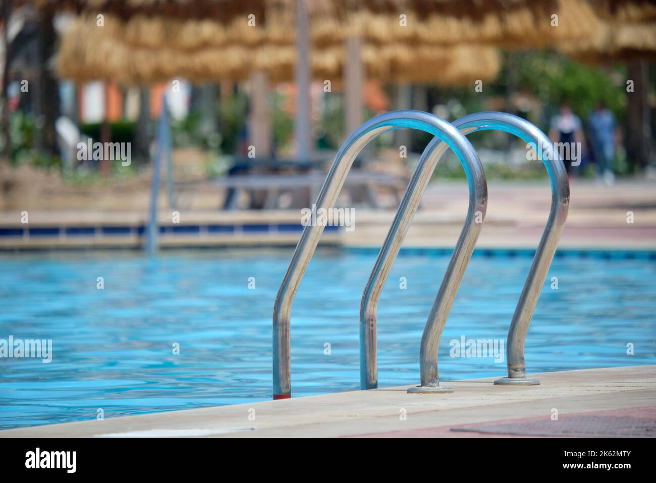Close up of swimming pool stainless steel handrail descending into ...