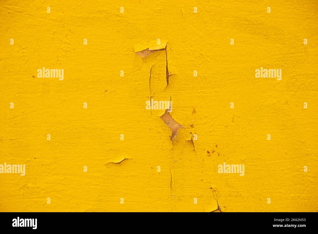 Facade of a house wall with yellow peeled paint as a background, a wall ...