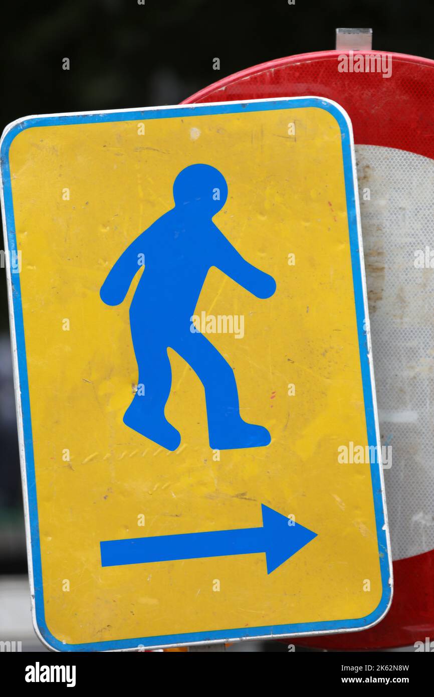 little blue man on the sign with arrow in a road construction site ...