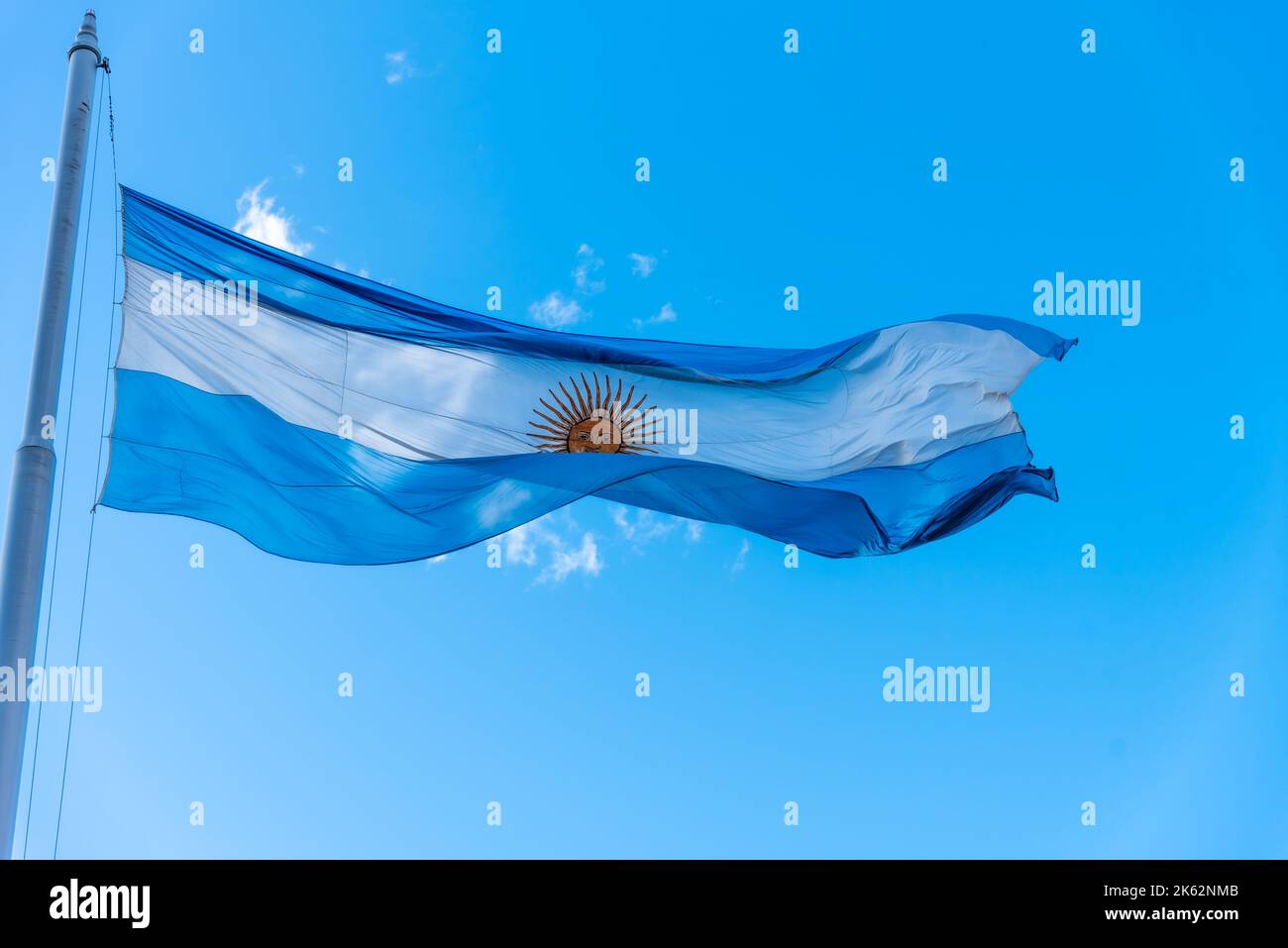 Argentine flag flying on a mast against a sunny blue sky. Argentina's ...