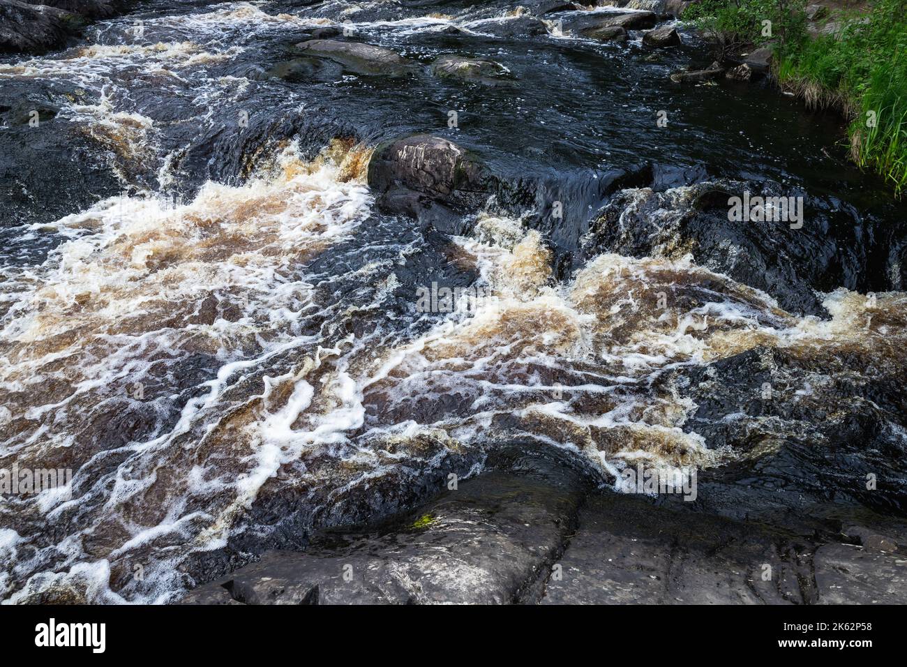 Abstract natural photo with fast stream water going over rocks in a ...