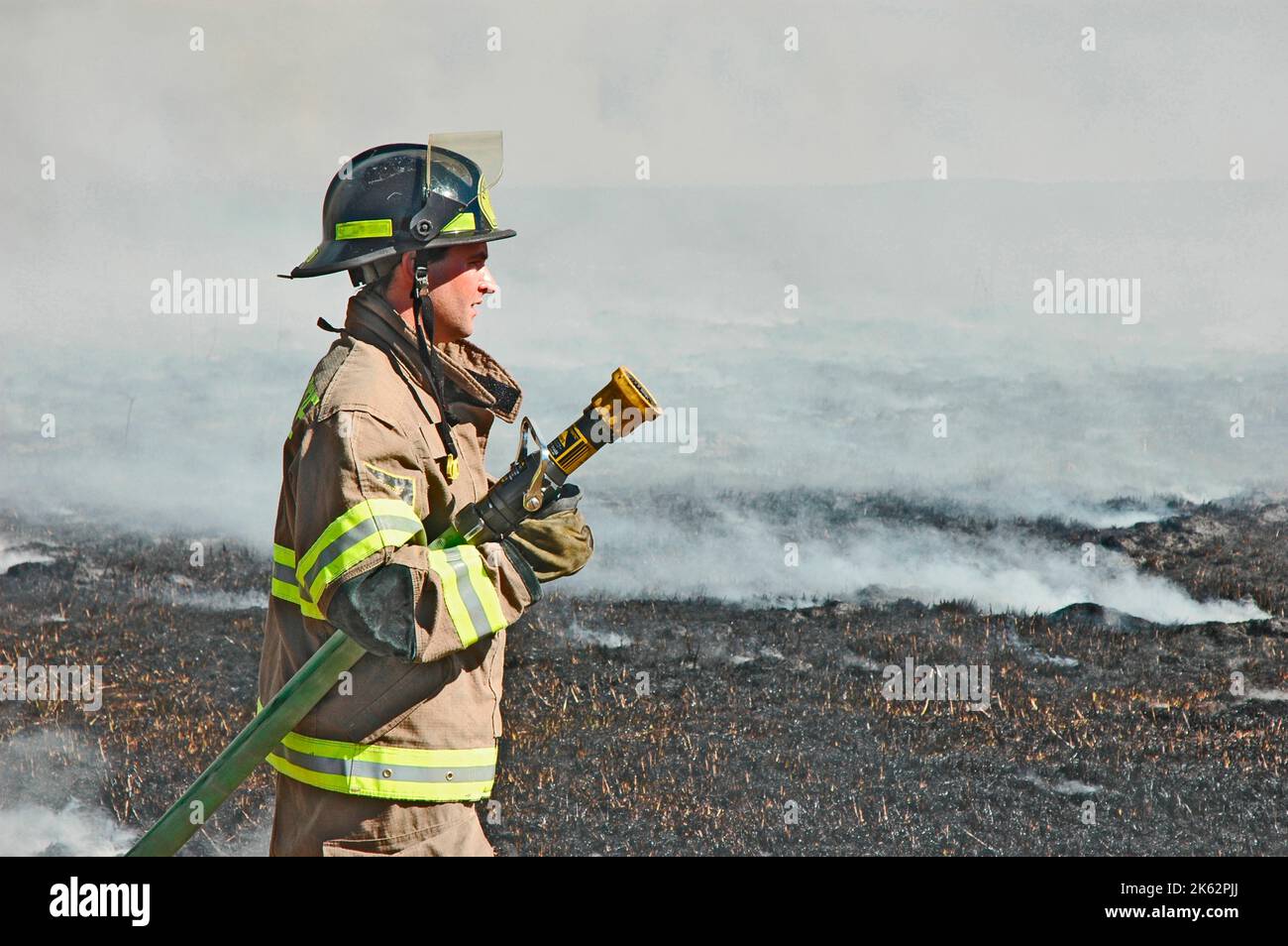 Firemen fighting a small brush fire in the Atlanta area with water and ...