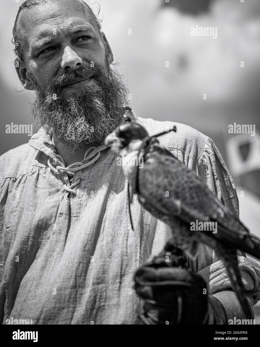 A vertical grayscale shot of a bearded man holding a falcon Stock Photo ...