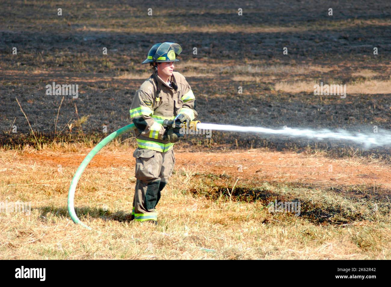 Firemen fighting a small brush fire in the Atlanta area with water and ...