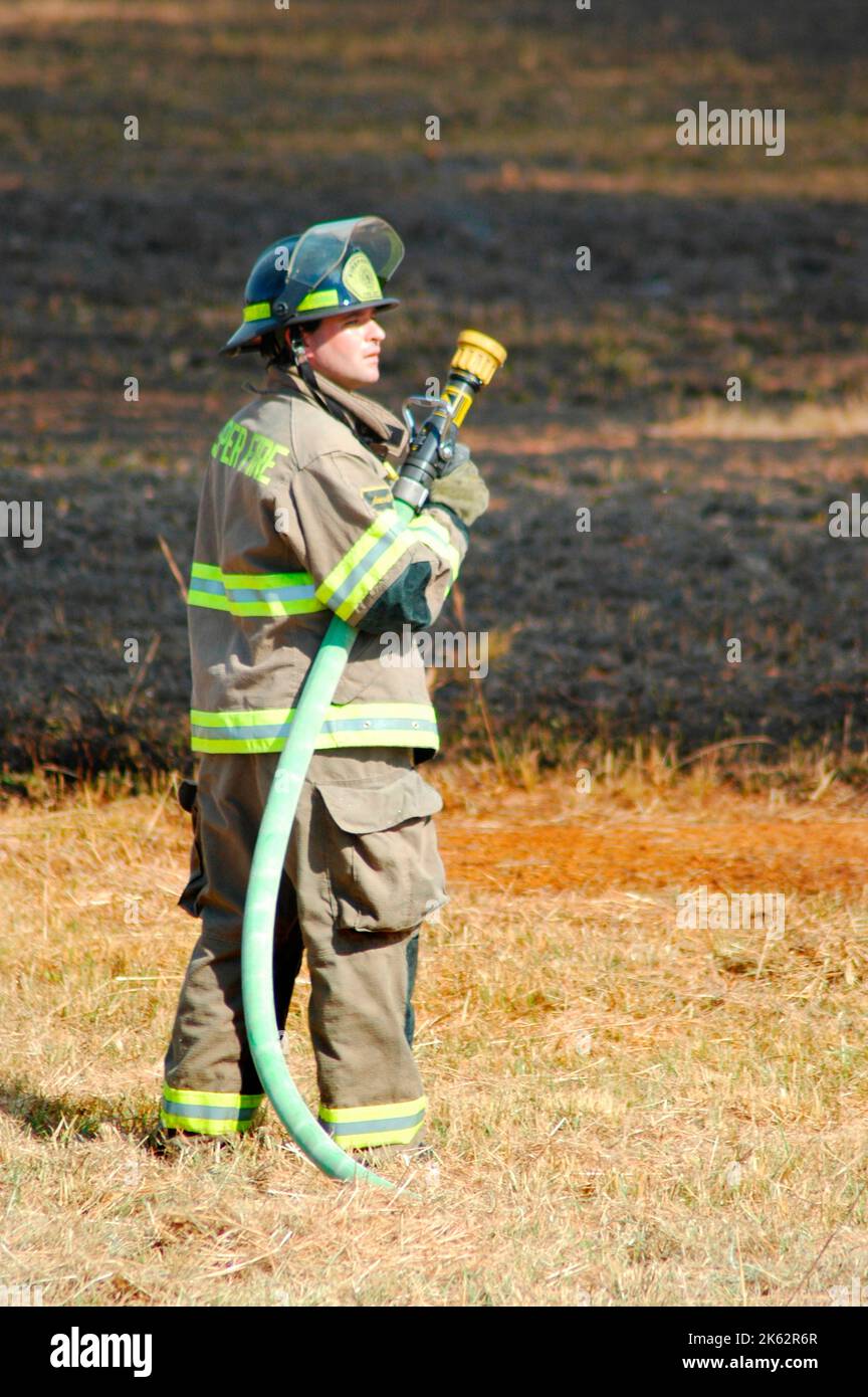 Firemen fighting a small brush fire in the Atlanta area with water and ...